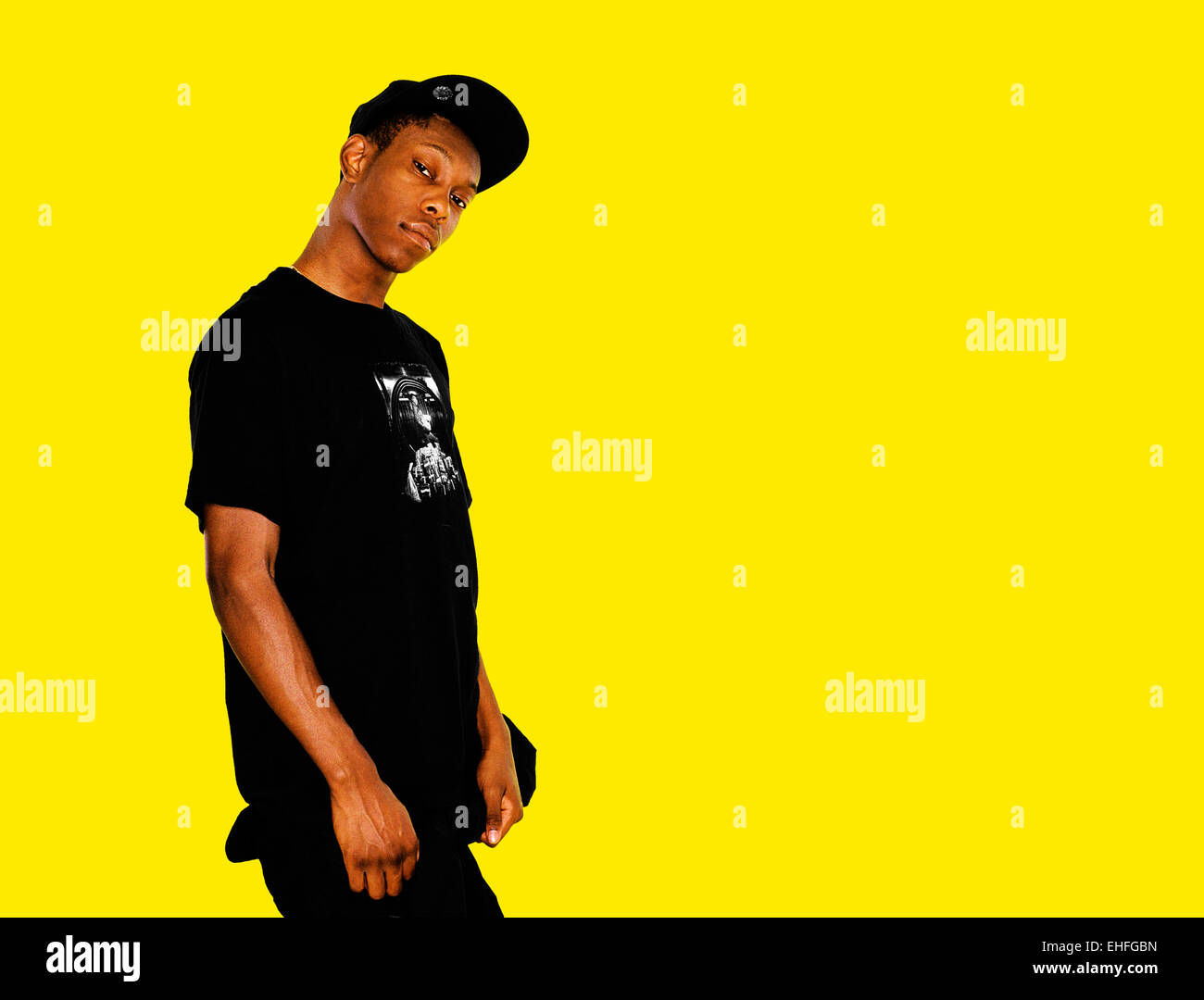 Portrait of Dizzee Rascal against yellow background Stock Photo - Alamy