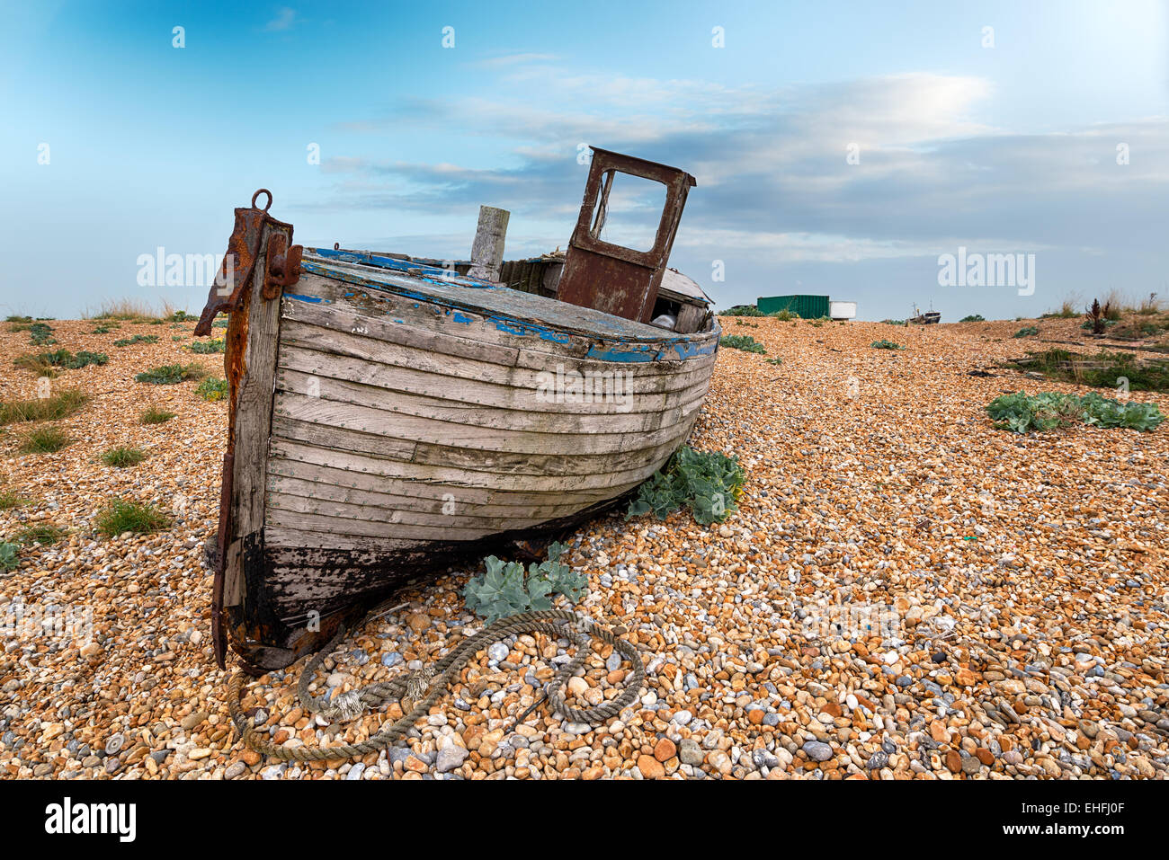 A weathered old wooden fishing boat on a shingle beach Stock Photo - Alamy
