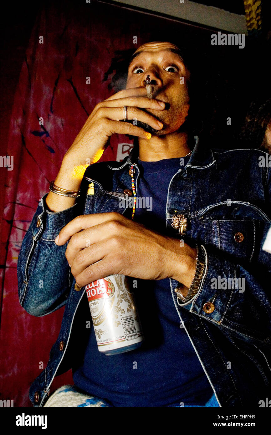 Guy smoking a spliff and having a beer at a squat party London Stock ...