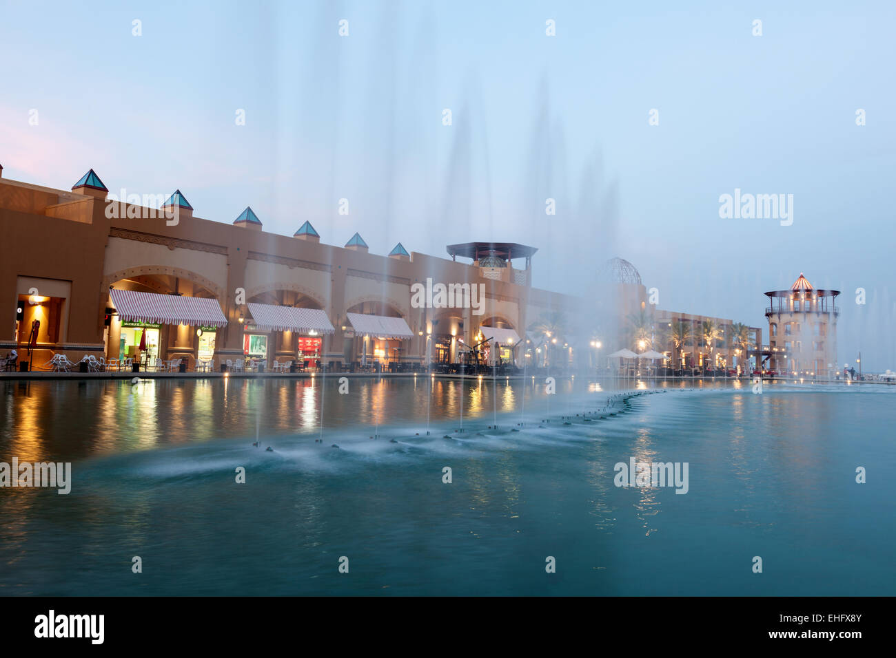 Fountain in the Al Kout Mall at dusk. Al Kout Mall is a modern shopping ...