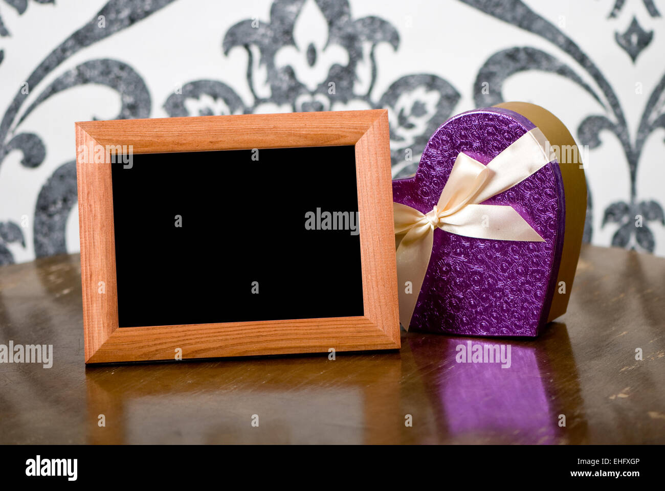 Wooden photo frame and present box on table Stock Photo - Alamy