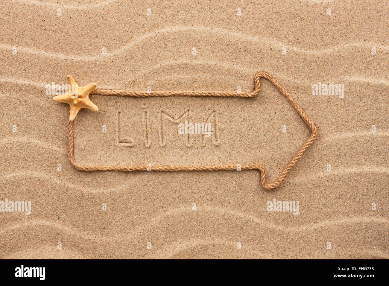 Arrow made of rope and sea shells with the word Lima on the sand, as ...