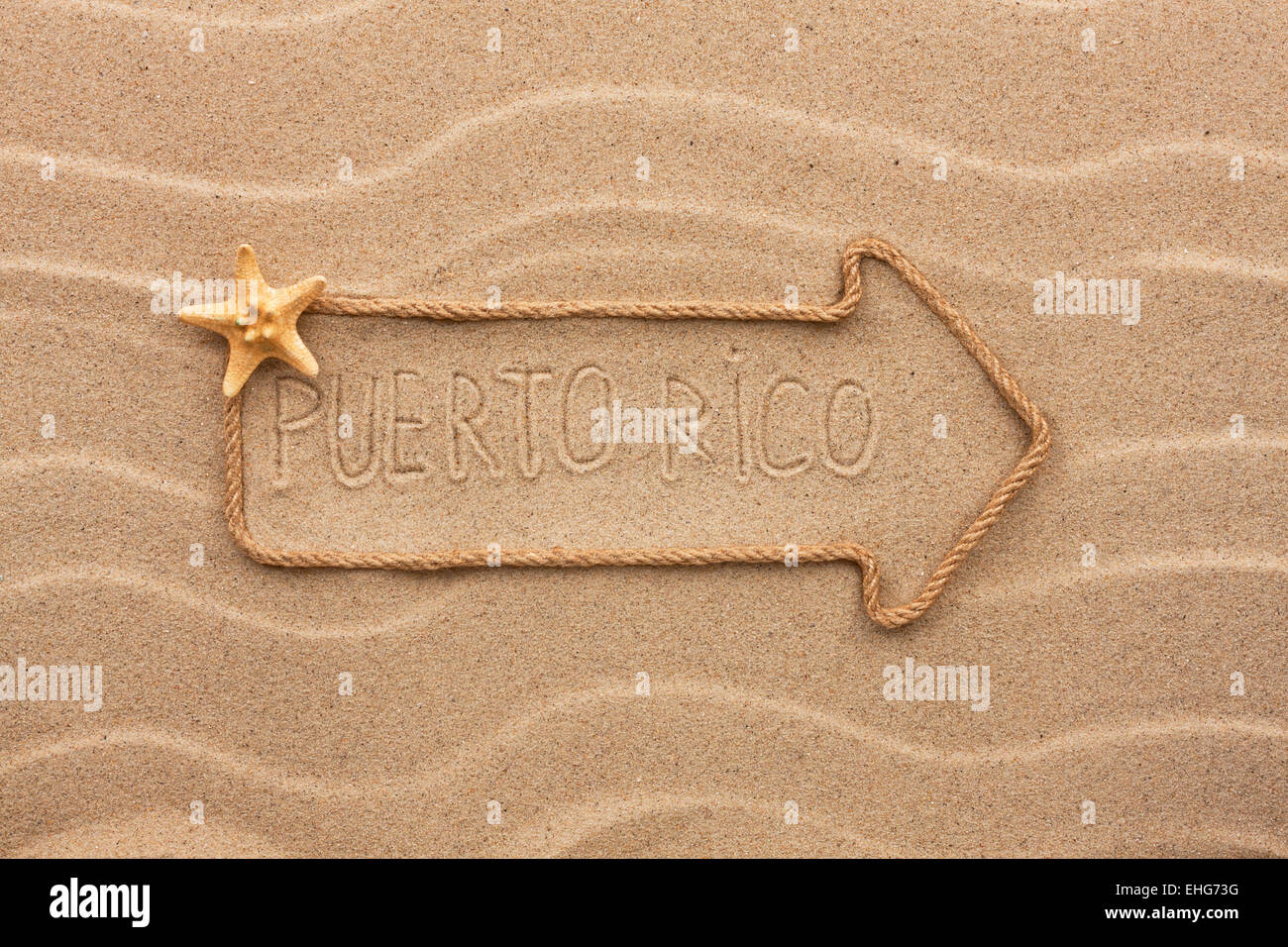Arrow made of rope and sea shells with the word Puerto Rico on the sand ...