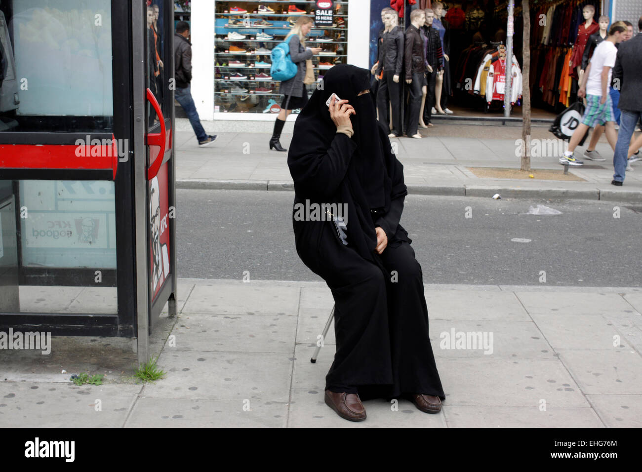 Muslim woman wearing a burka on her mobile phone in Camden, London ...
