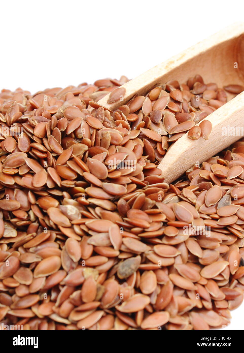 Heap of brown linseed with wooden spoon. Isolated on white background ...