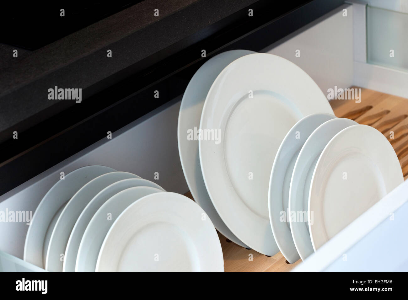 Porcelain plates in a modern kitchen drawer Stock Photo - Alamy