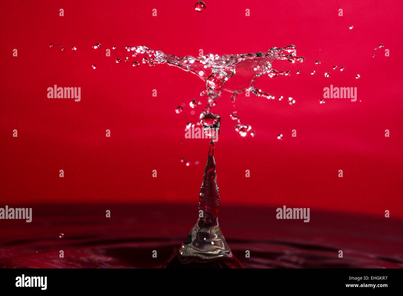Water drop collisions with a red background Stock Photo - Alamy