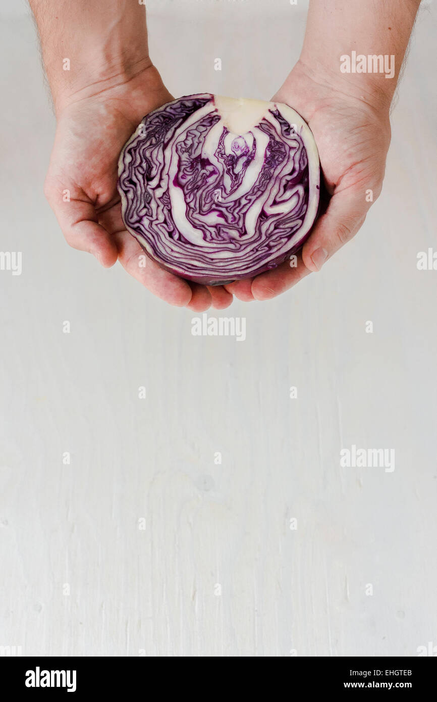 Young man holding half a red cabbage. Complexity Stock Photo - Alamy