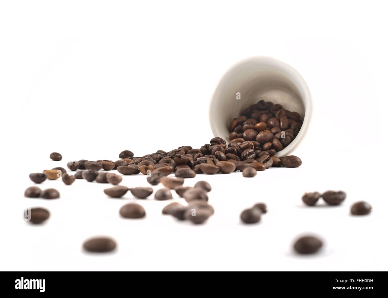 Spilled coffee beans from the cup isolated Stock Photo - Alamy