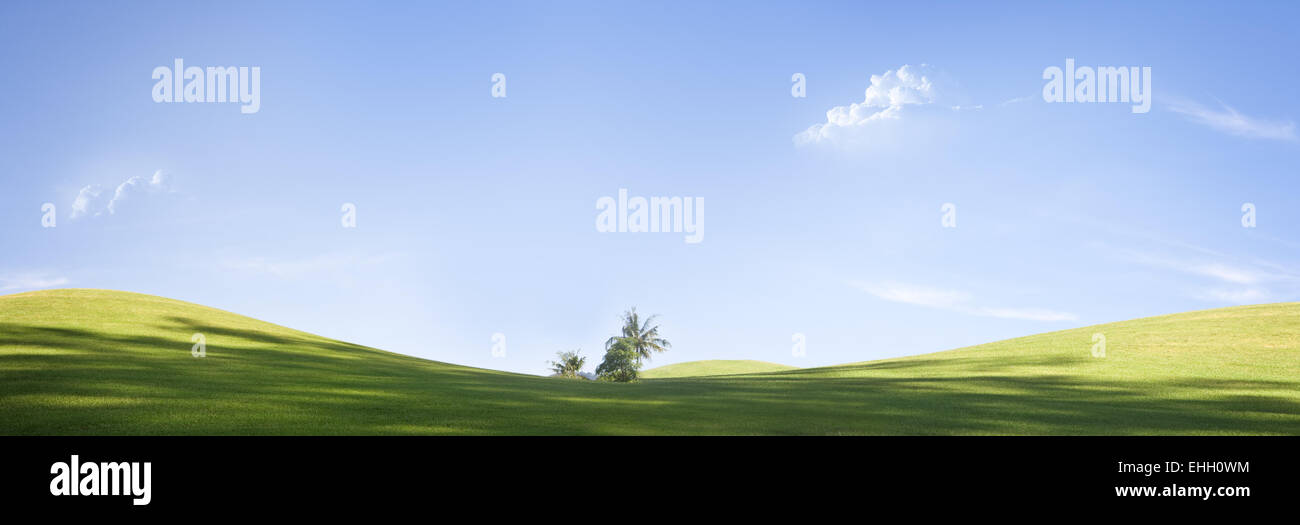 view of nice green hill on blue sky background Stock Photo - Alamy