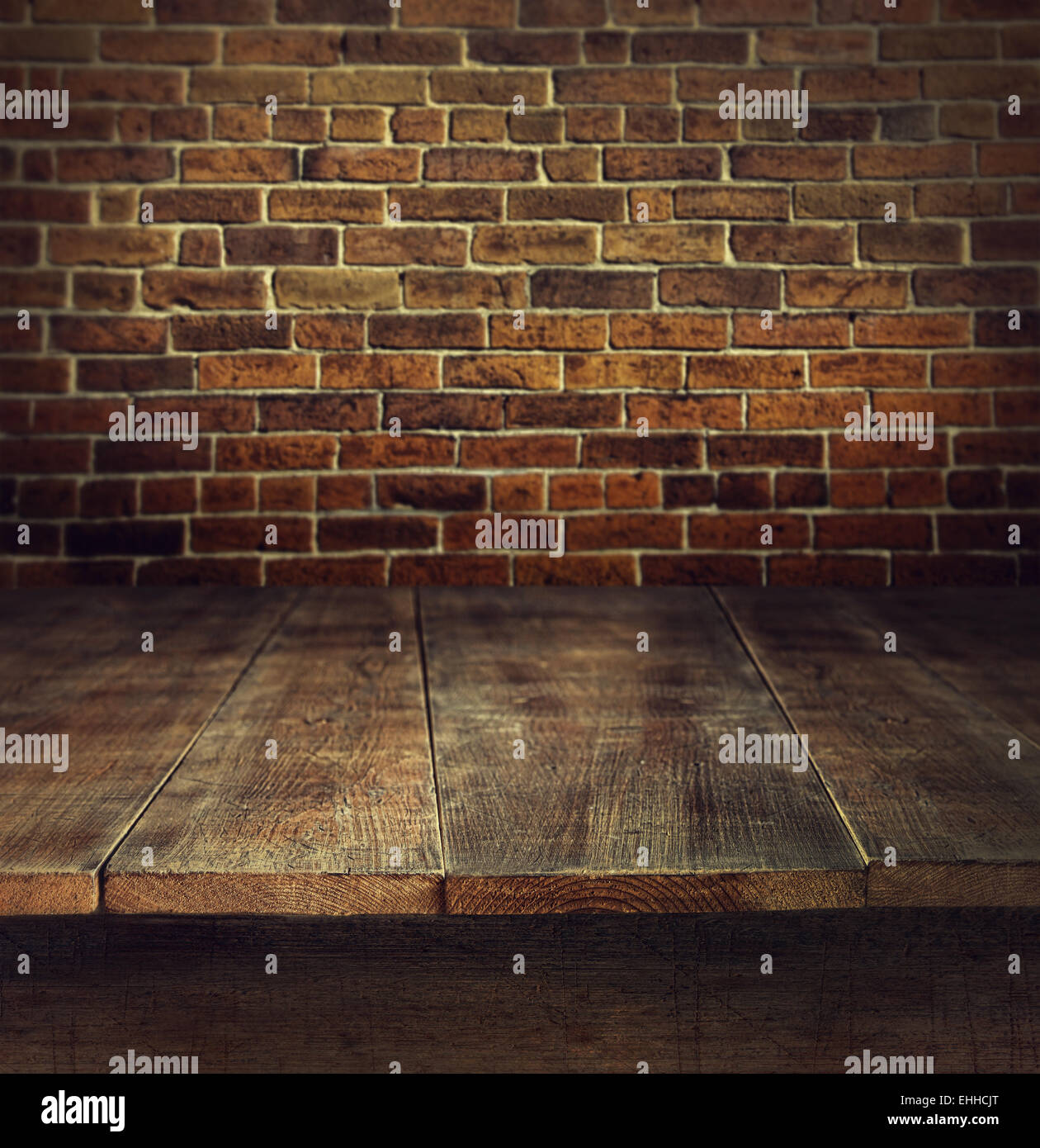 Old wooden table with brick background Stock Photo - Alamy