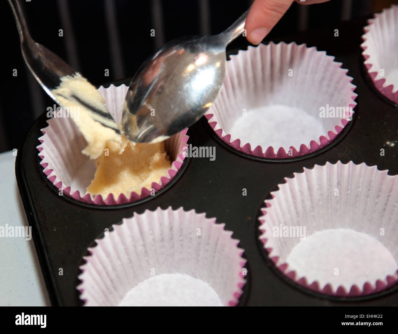 Cake mix batter dropped into paper cake cups Stock Photo - Alamy