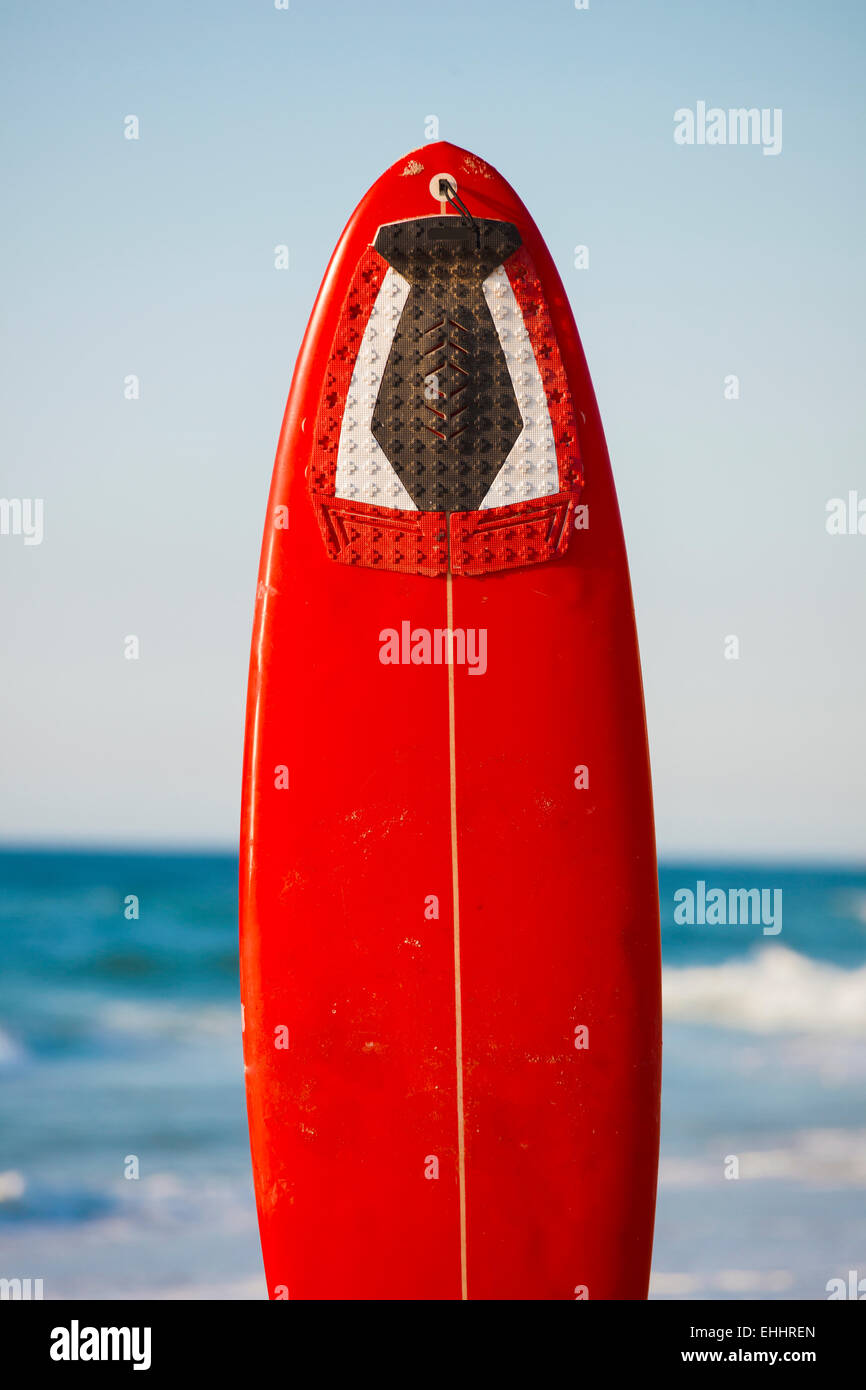 Red surfboard on the sand on a very beautiful sunny day Stock Photo - Alamy