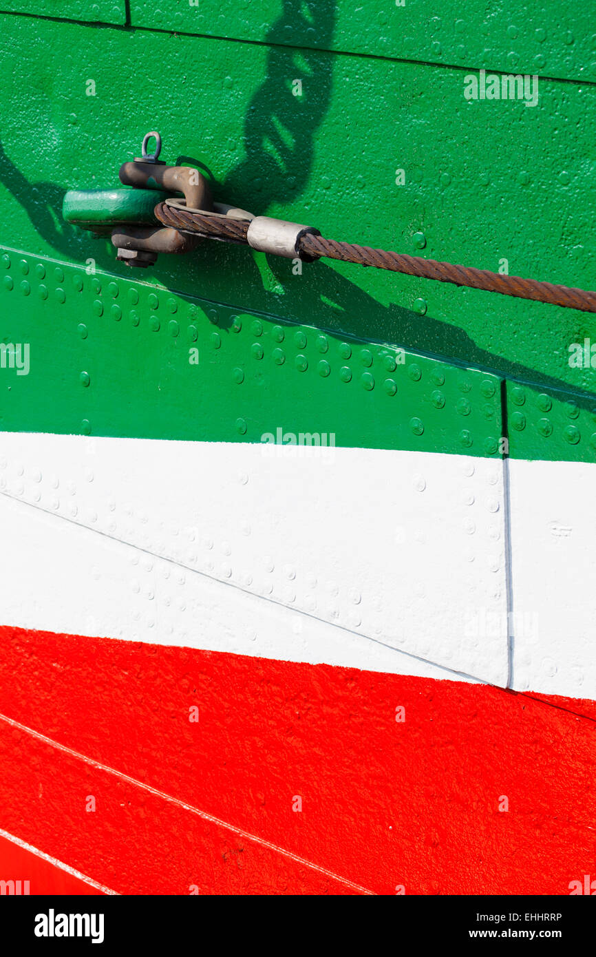 A colorful ship hull in green, white and red with some ropes Stock ...