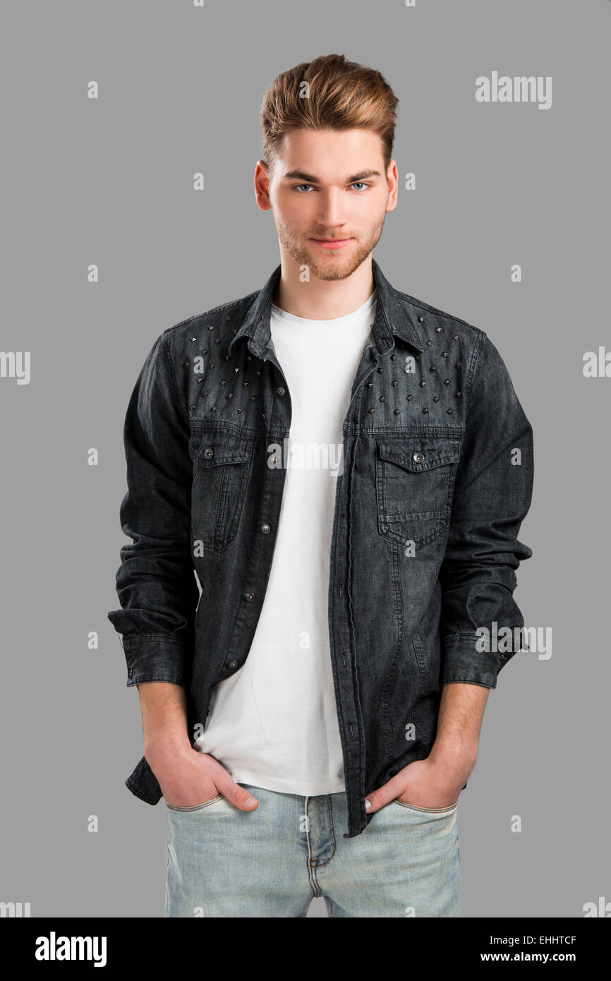 Good looking young man smiling with hands in the pockets, isolated over ...