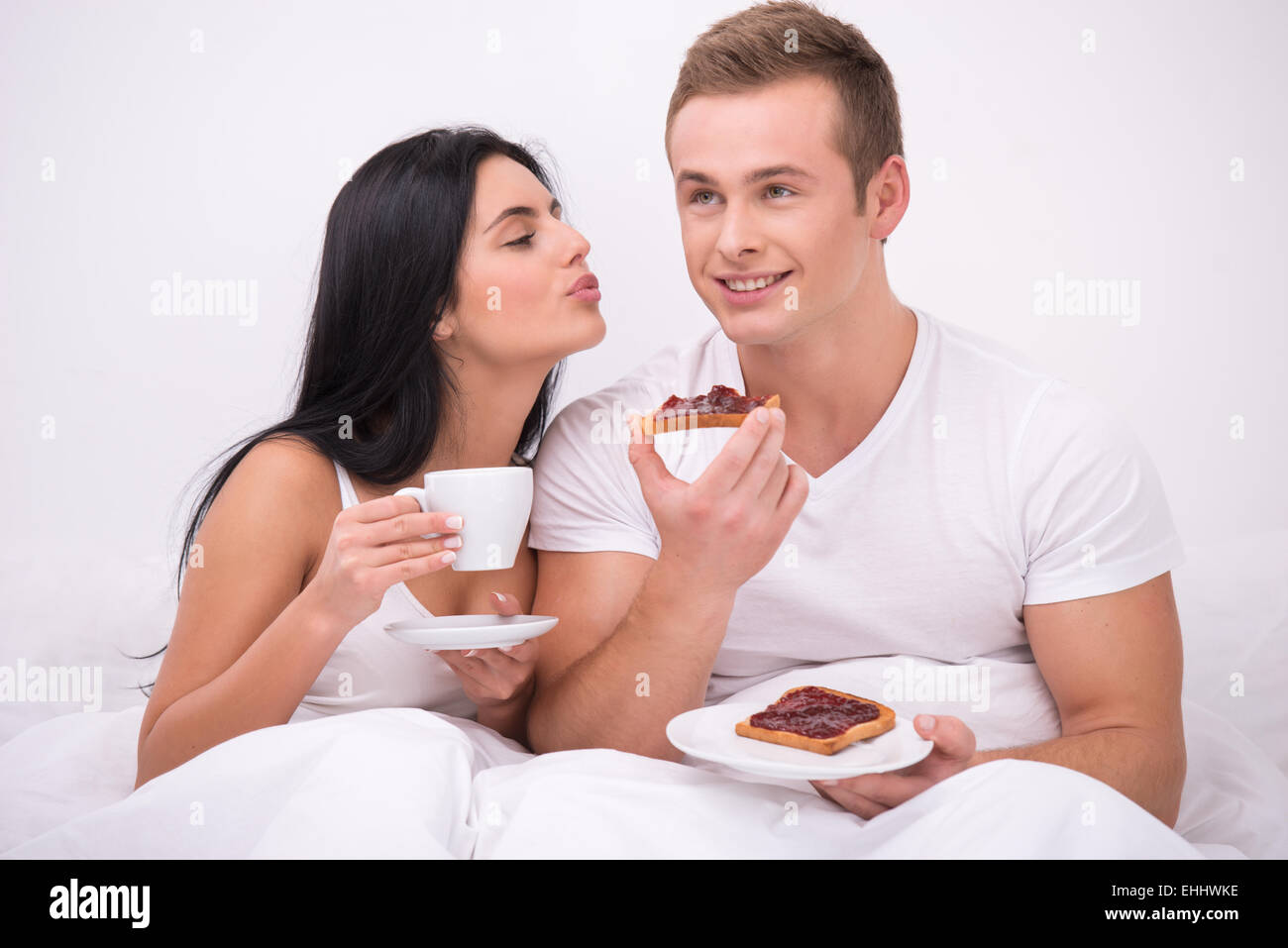 Couple eating toasts with jam in bed Stock Photo - Alamy