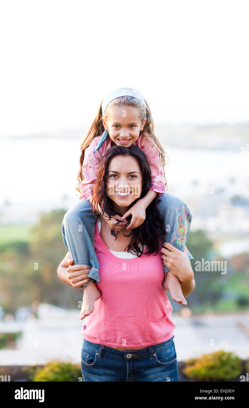 Mother giving daughter piggyback ride Stock Photo - Alamy