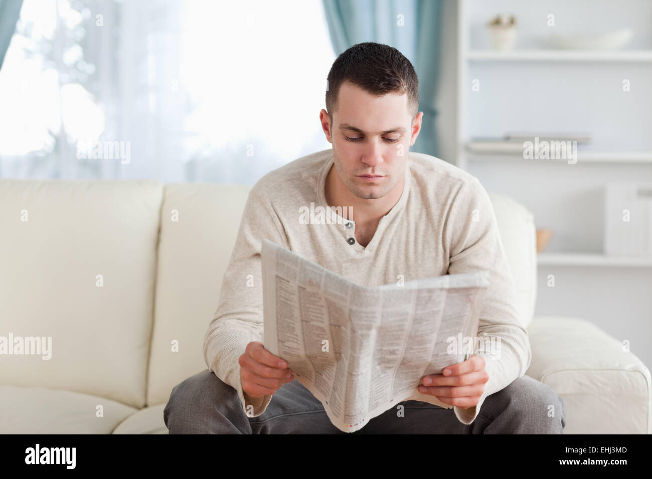 Serious man reading a newspaper Stock Photo - Alamy