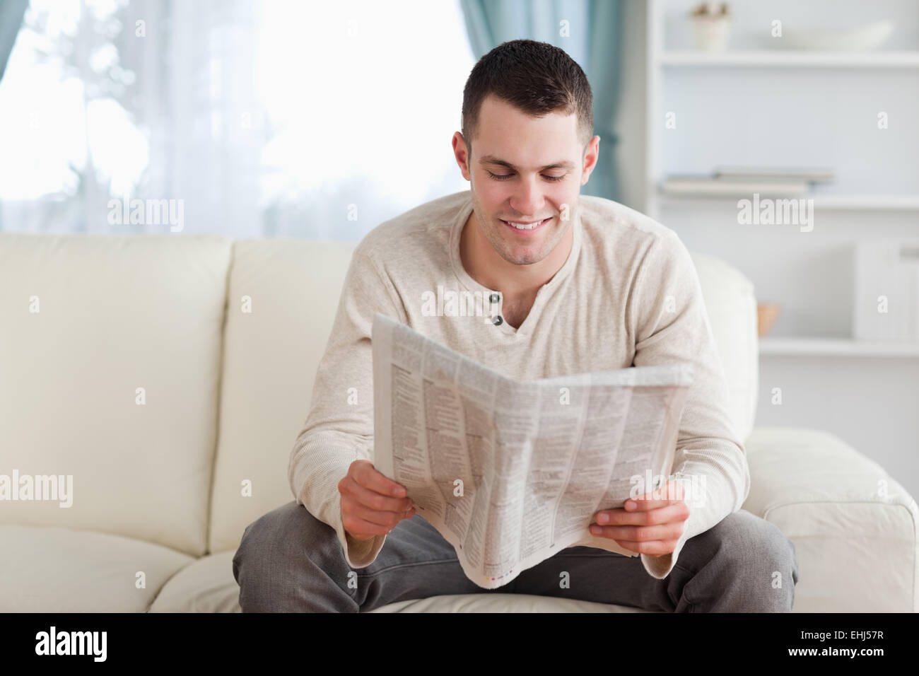 Happy man reading a newspaper Stock Photo - Alamy