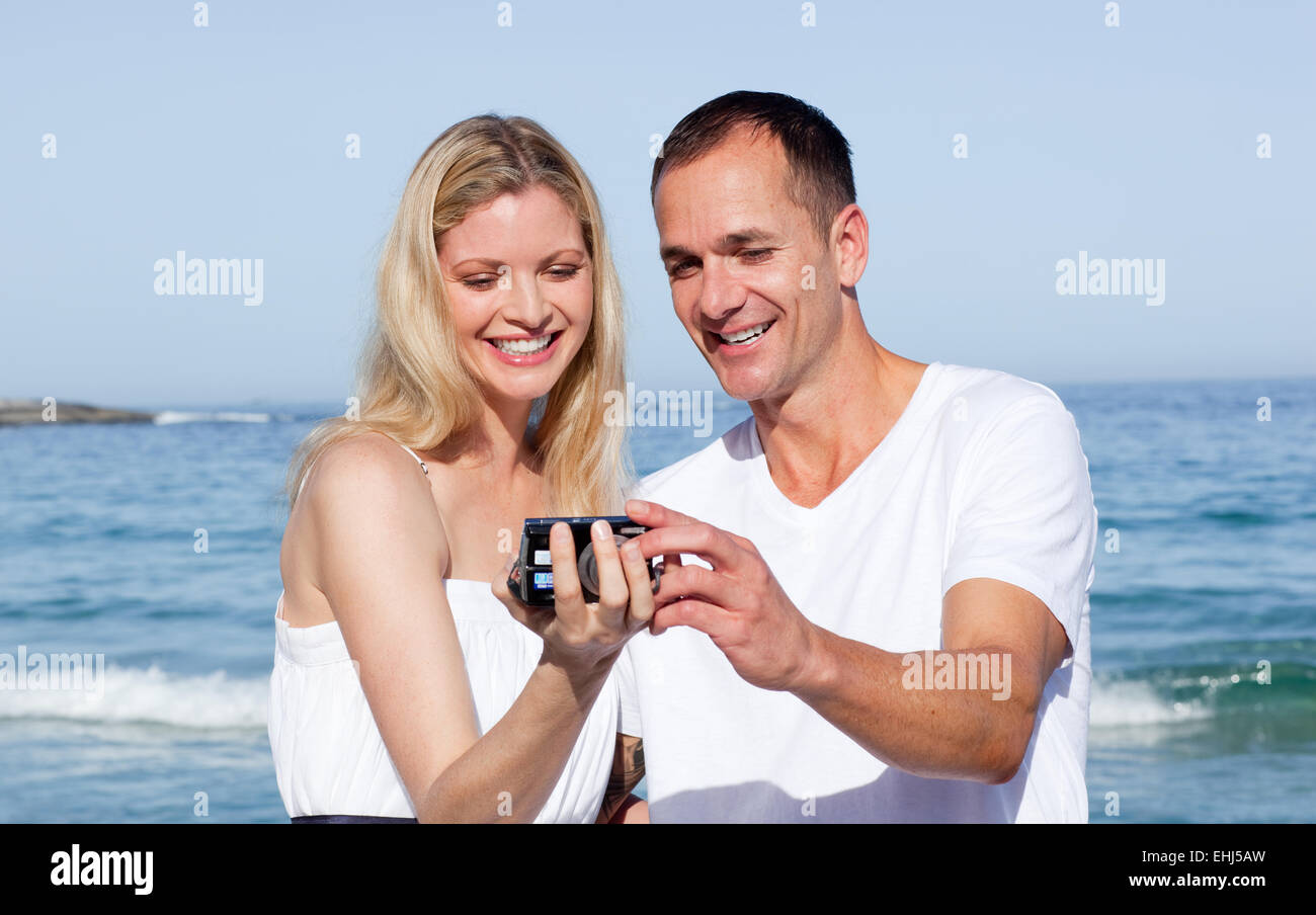 Enamored couple looking at holiday photograph Stock Photo - Alamy