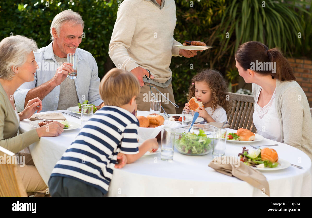 Adorable family eating in the garden Stock Photo - Alamy