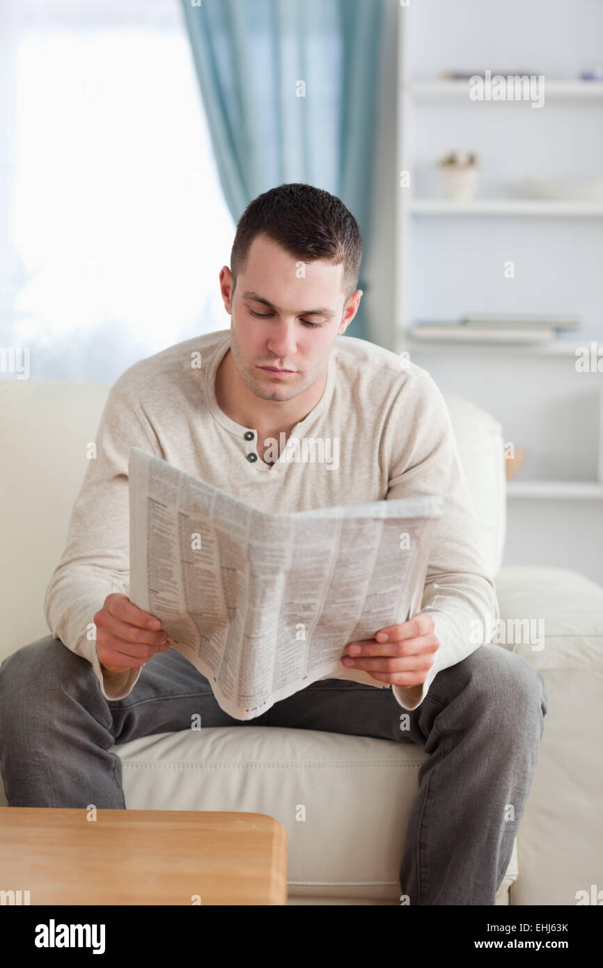 Portrait of a young man reading a newspaper Stock Photo - Alamy
