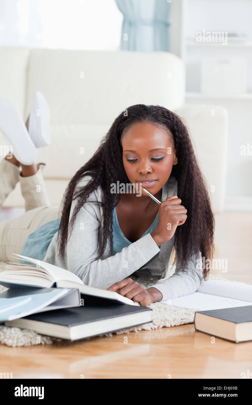 Female student lying on floor doing homework Stock Photo - Alamy