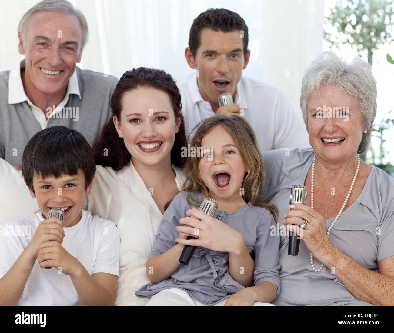 Family singing karaoke at home Stock Photo - Alamy
