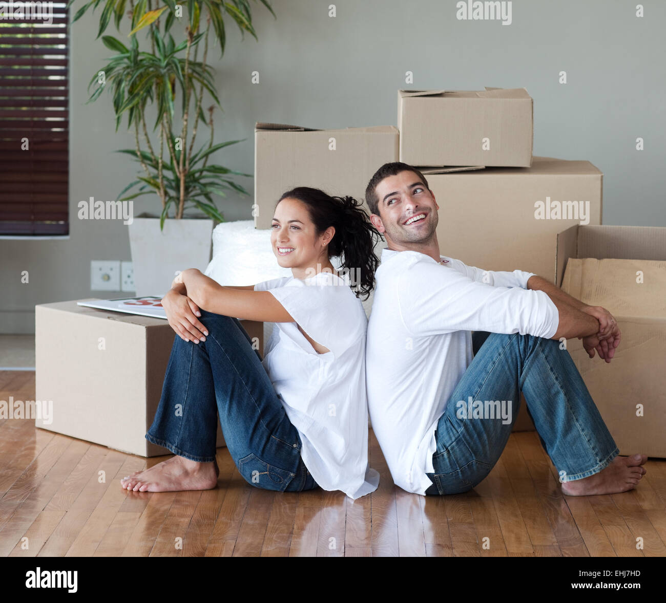 Glowing couple sitting on the floor Stock Photo - Alamy