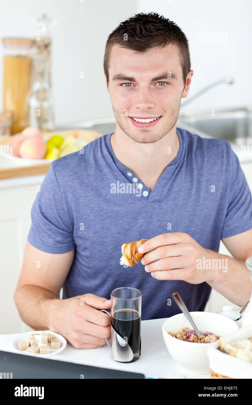 Handsome man eating croissant drinking coffee Stock Photo - Alamy