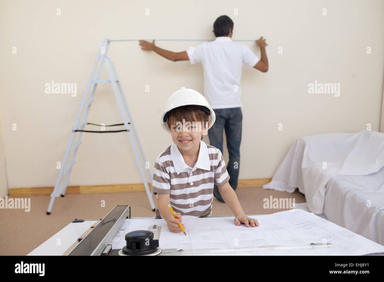 Little son drawing plans and father working Stock Photo - Alamy