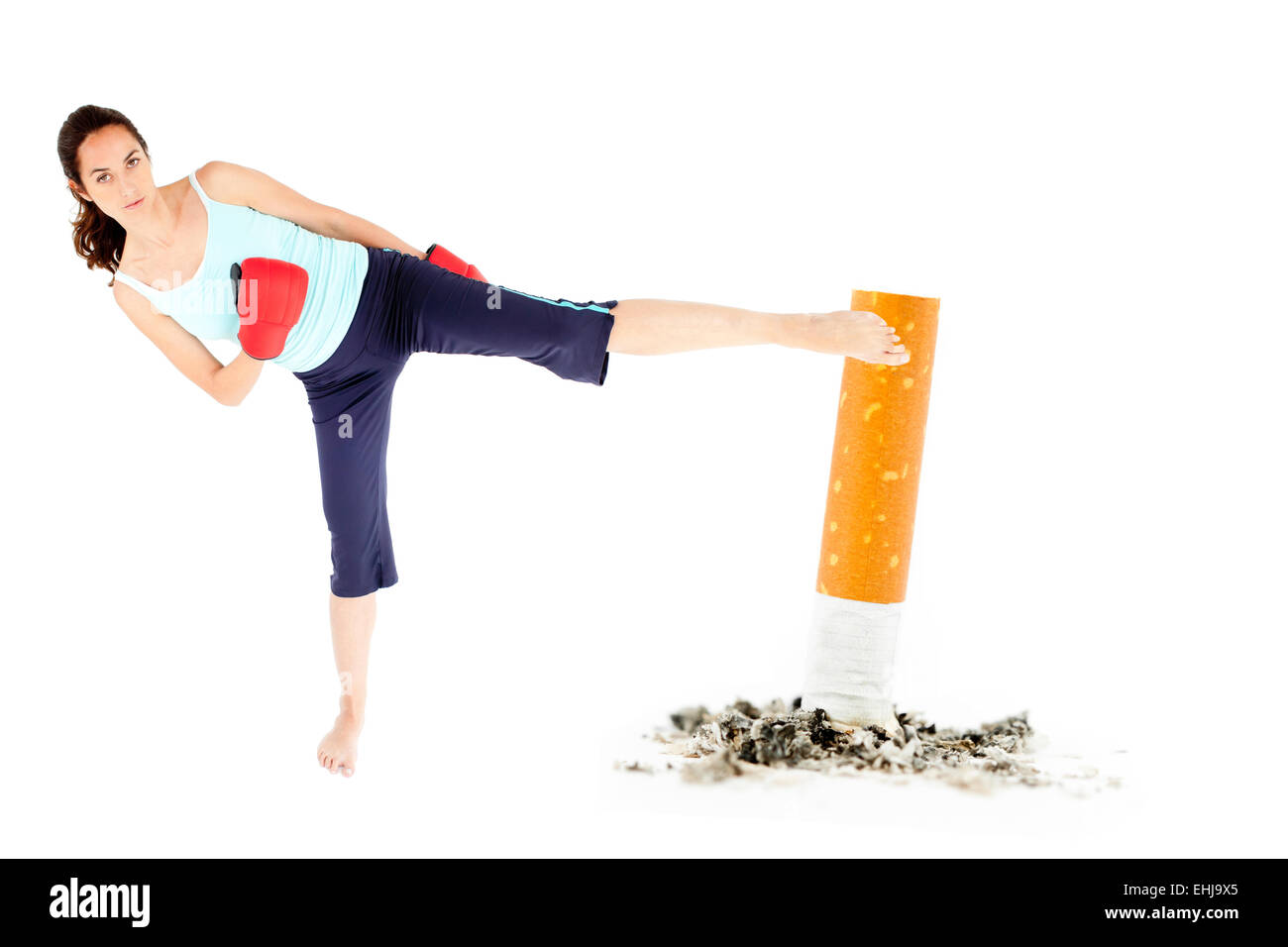 Woman kicking a giant cigarette Stock Photo - Alamy