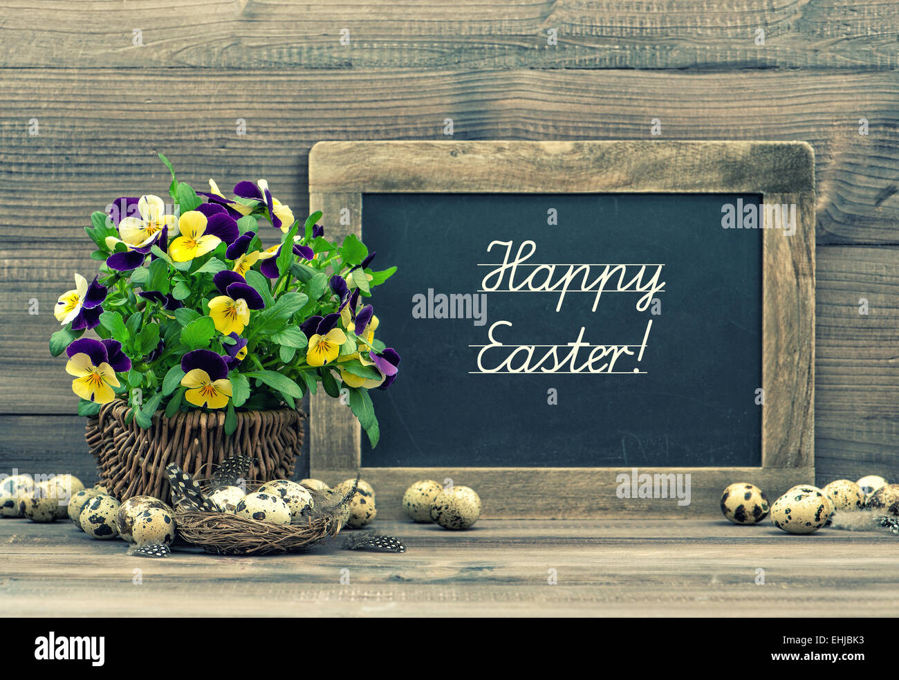 Easter decoration eggs, pansy flowers and vintage blackboard with ...