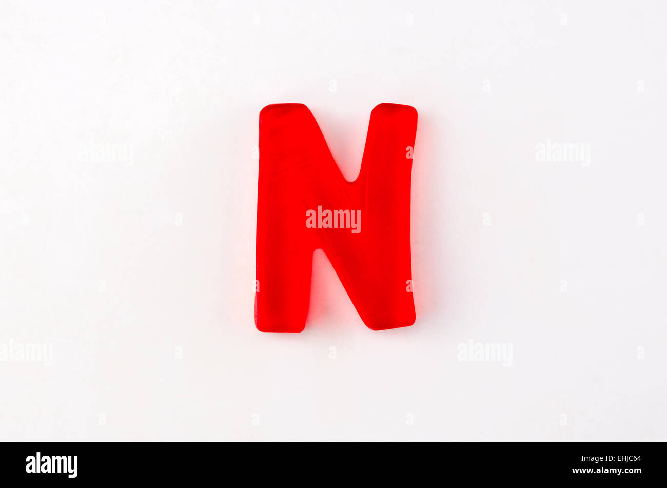 A red gummy letter in the shape of N isolated on white Stock Photo - Alamy