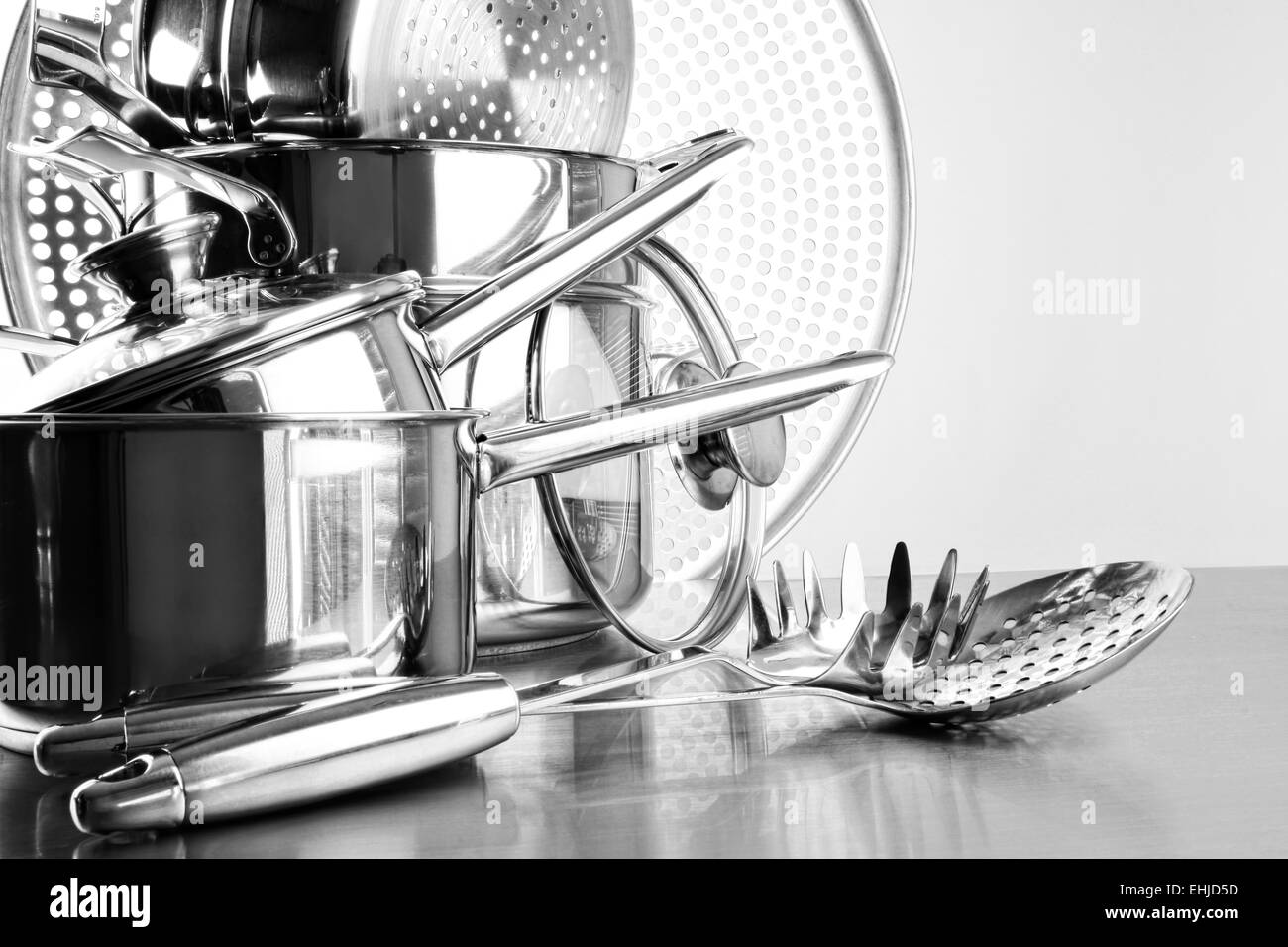 Stainless steel pots and utensils on table Stock Photo - Alamy