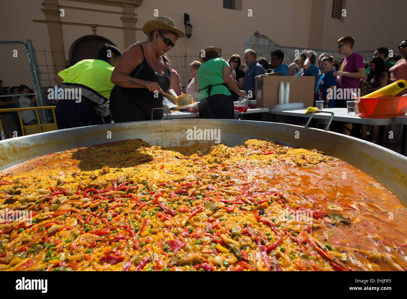 A chef serves portions of paella to townsfolk at the Fiesta de San ...