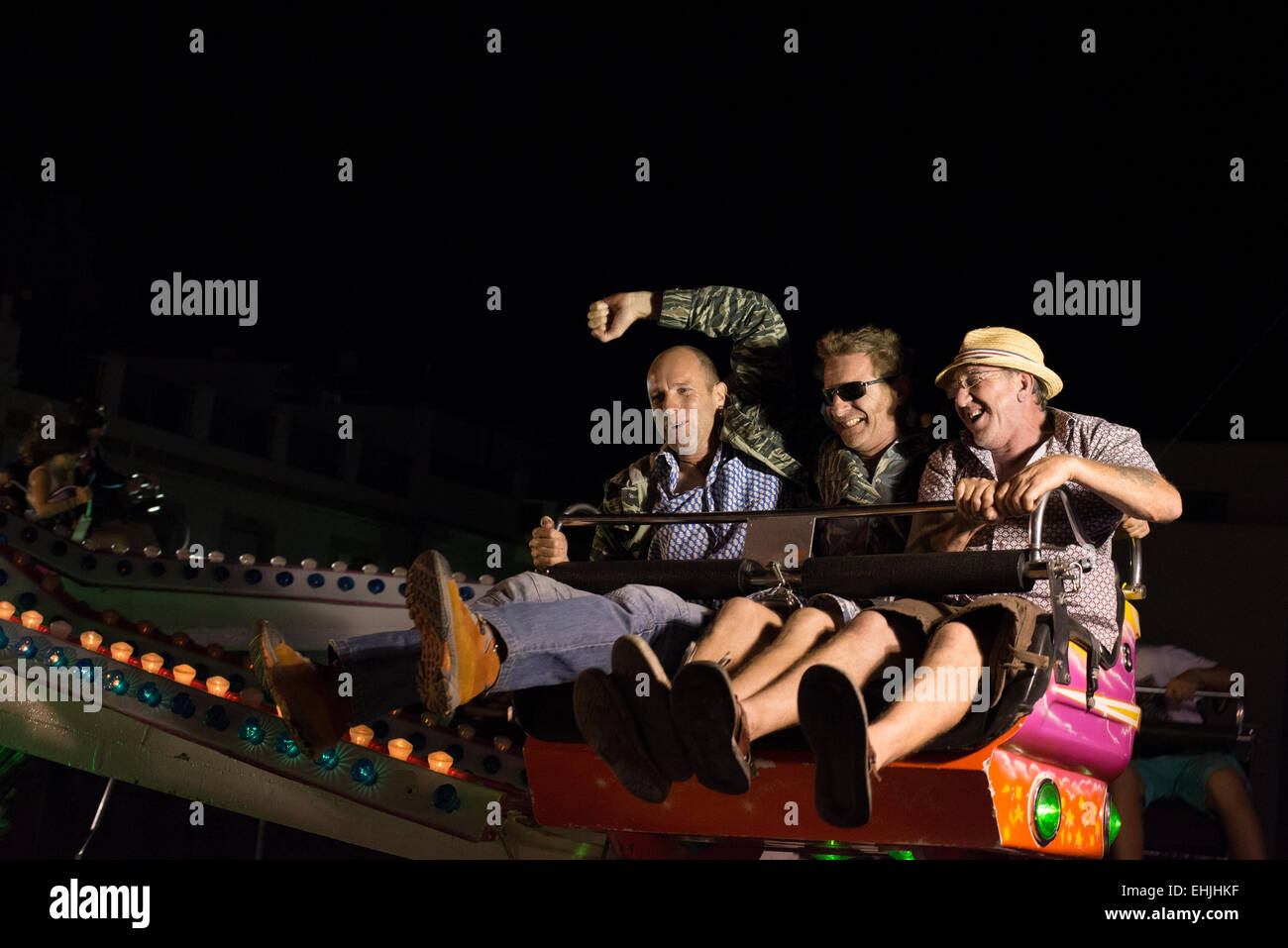 Revellers enjoy a fairground ride at the Fiesta de San Miguel in Orgiva ...
