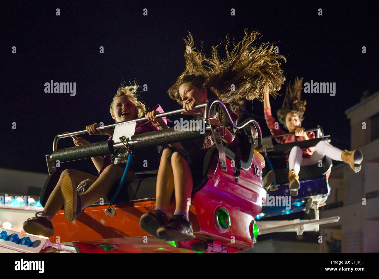 Teenagers enjoy a fairground ride at the Fiesta de San Miguel in Orgiva ...
