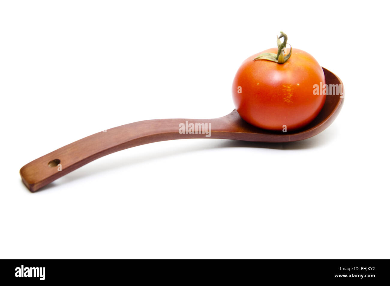 Tomato on wooden spoon Stock Photo - Alamy