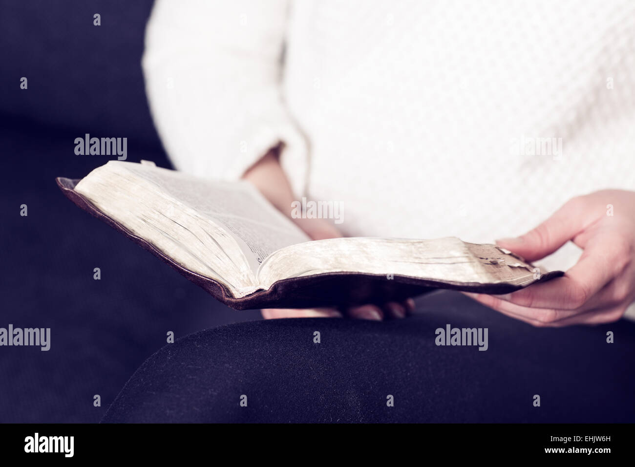 Christian woman reading the holy bible at home. Sitting in sofa Stock ...