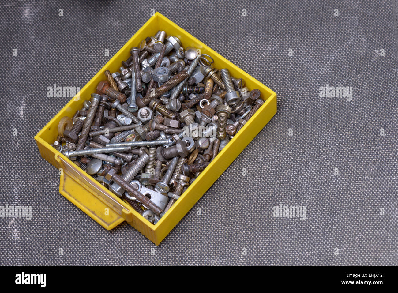 Yellow old box with several screws Stock Photo - Alamy