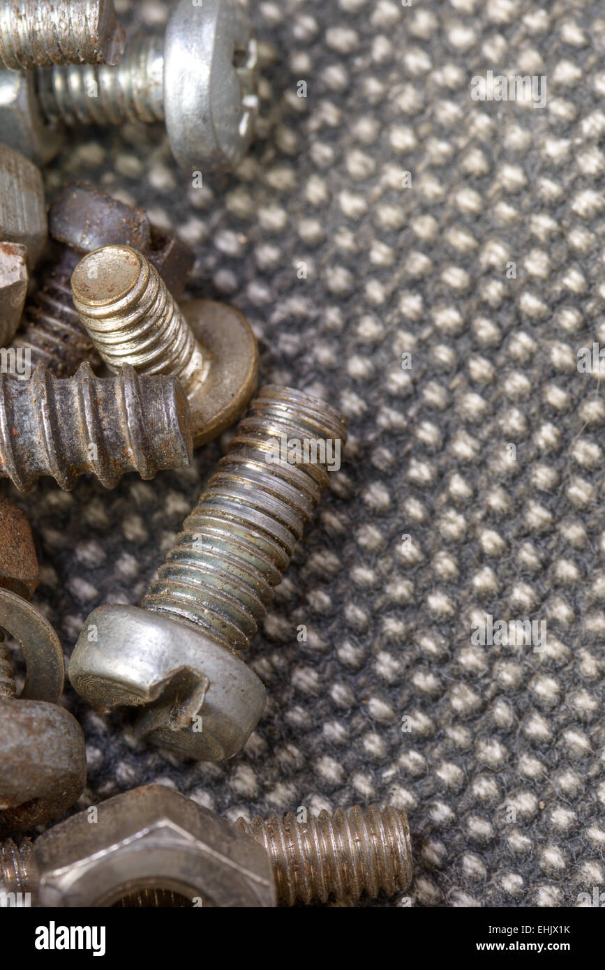 Several old screws on a grey texile background Stock Photo - Alamy