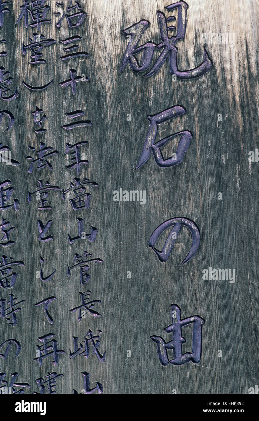 A carved wooden sign with colorful kanji characters evokes the mystical ...