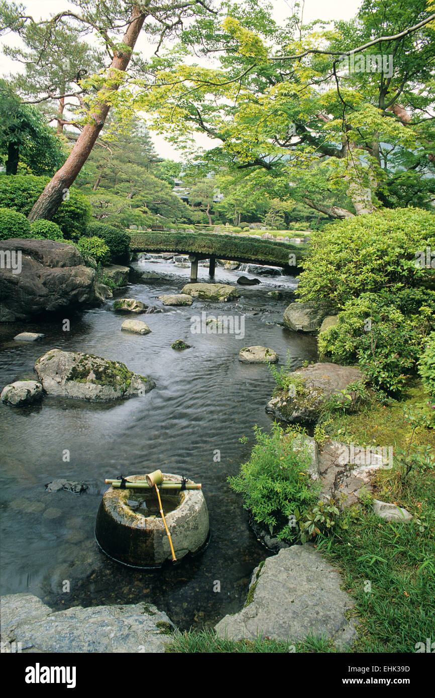 An archetypal Japanese Zen garden featuring a stream, pine trees, a ...