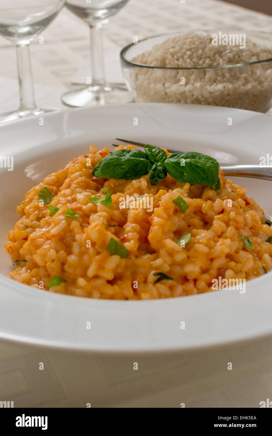 Red risotto with tomato and basil on white plate Stock Photo - Alamy