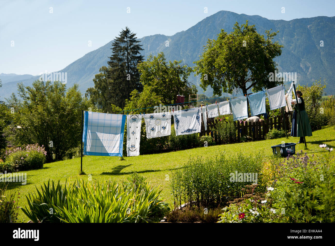 woman hanging out the laundry in her garden in Altaussee, Styria ...