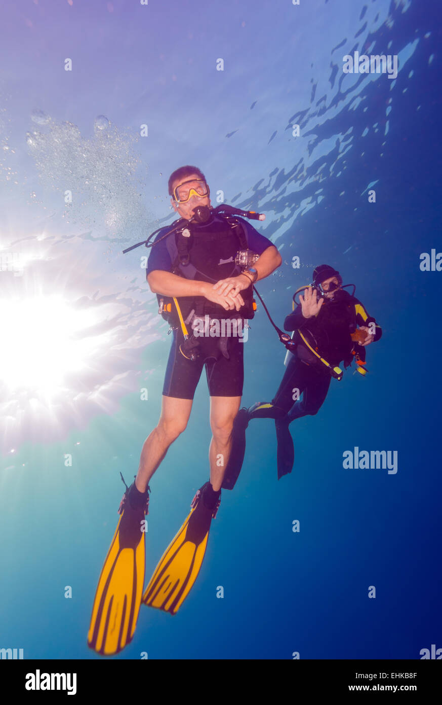 Two Male Scuba Divers with Sun Disc Behind Stock Photo - Alamy