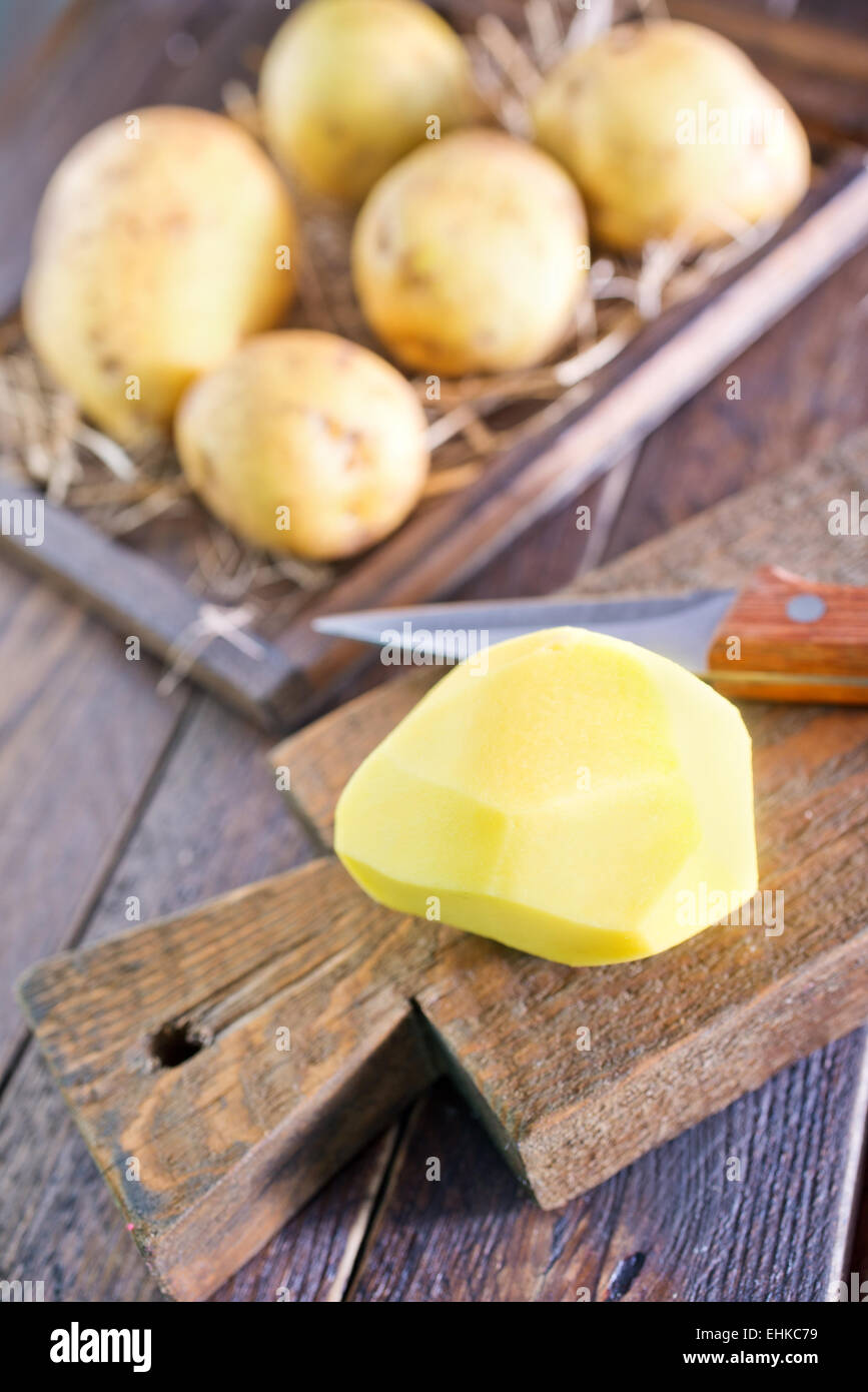 raw potato on board and on a table Stock Photo - Alamy