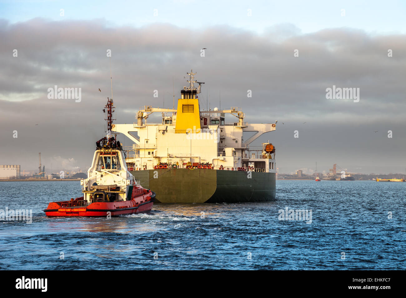 Tanker ship with escorting tug in port Stock Photo - Alamy
