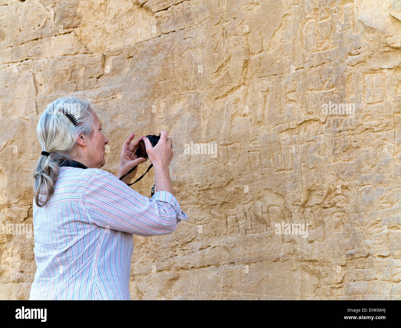 Female photographing rock art at Vulture Rock at the entrance to Wadi ...